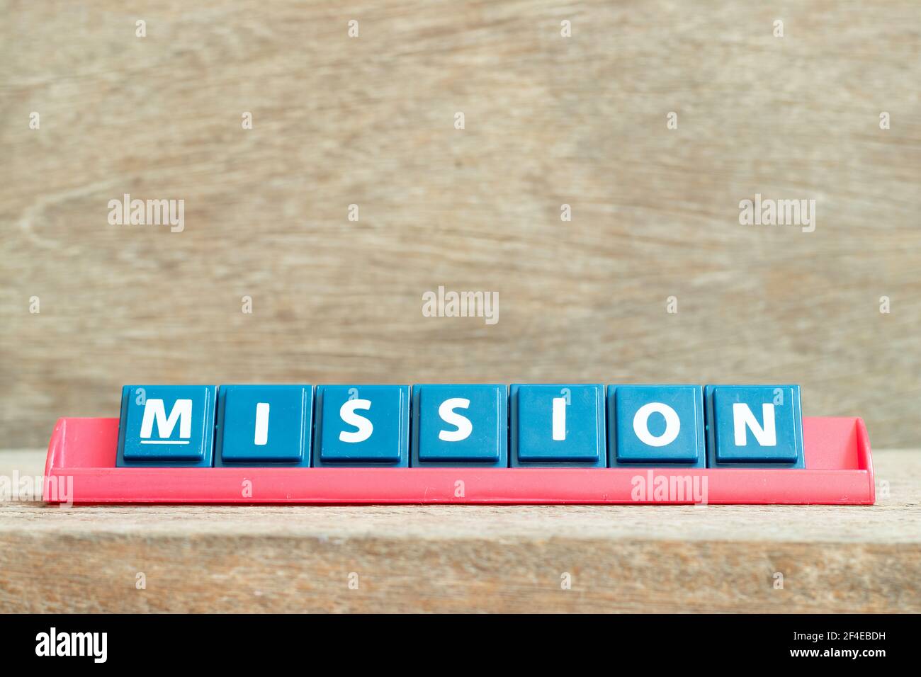Tile alphabet letter with word mission in red color rack on wood ...