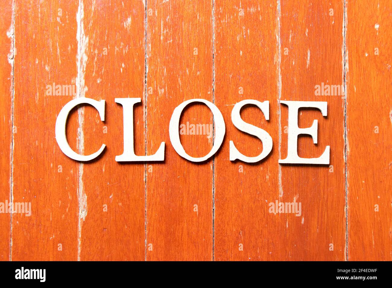 Alphabet letter in word close on old red color wood plate background ...