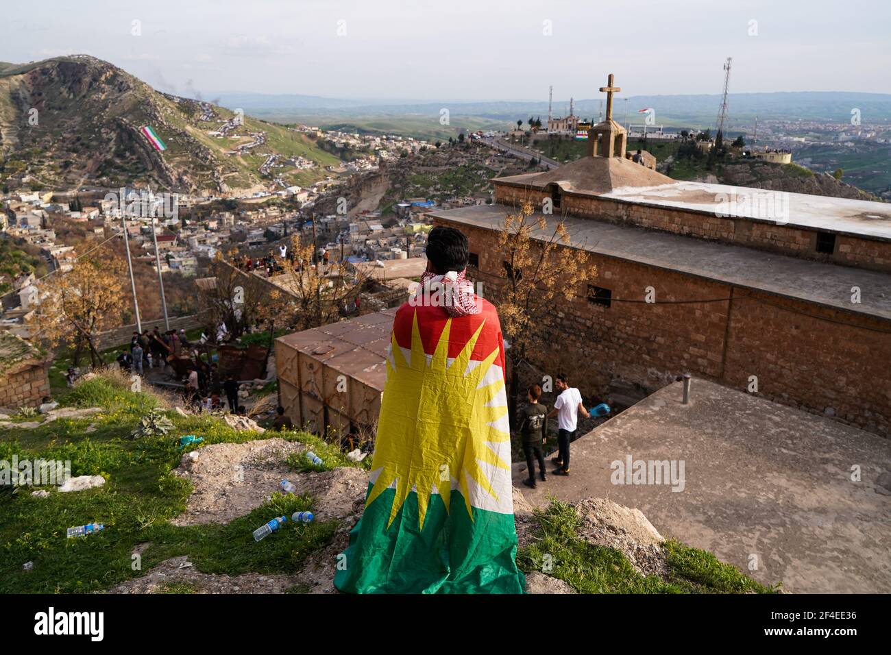 A man wrapped in a Kurdistan flag standing next to a church during the ...