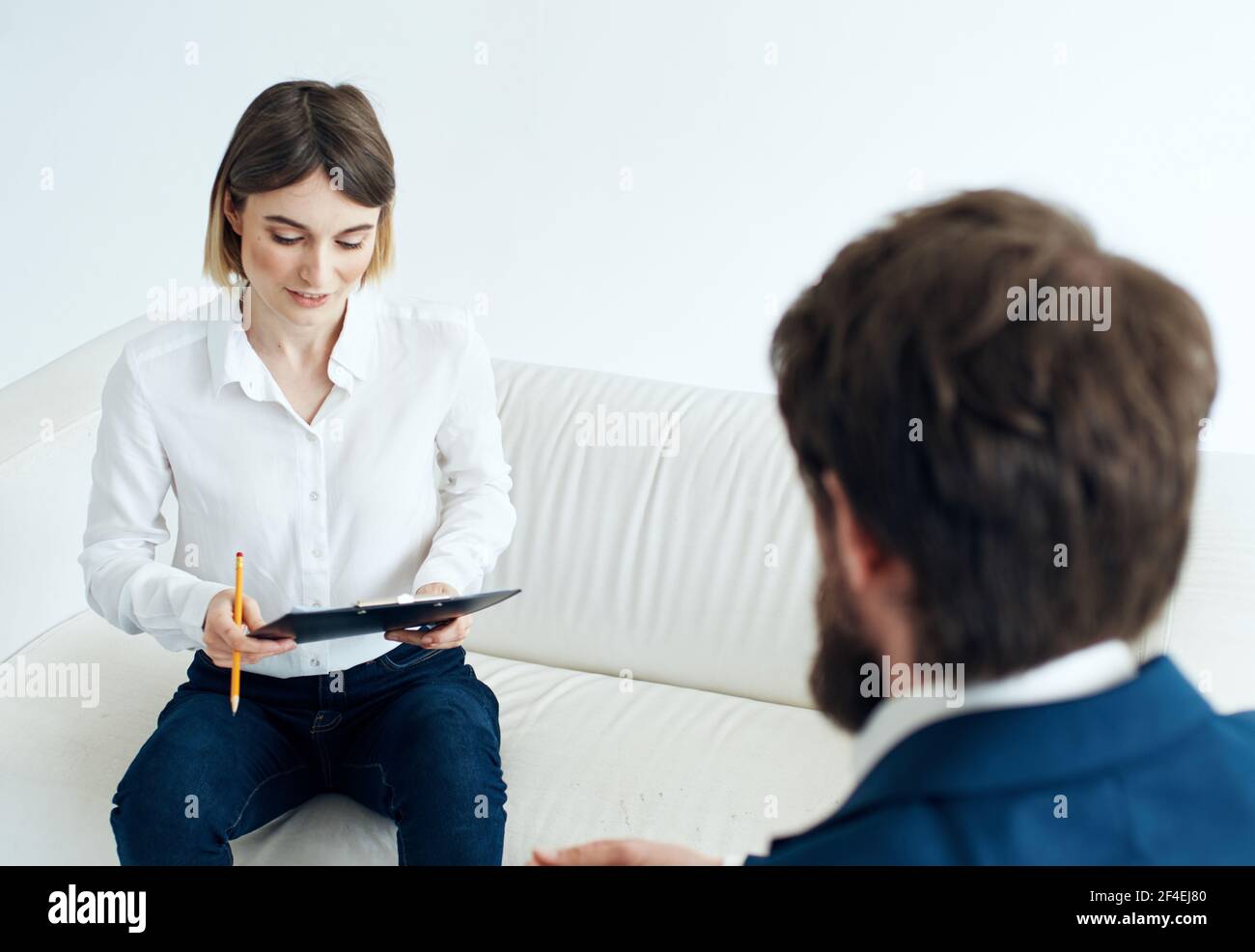 Woman with documents and a man in a suit are sitting on the couch ...