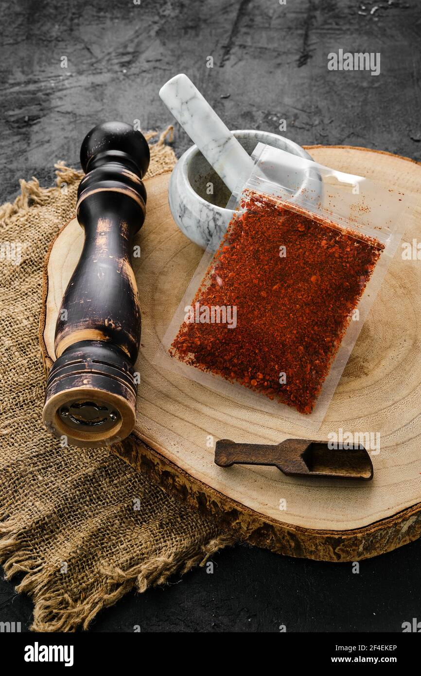Wooden cross section with paprika in plastic package and stone mortar ...