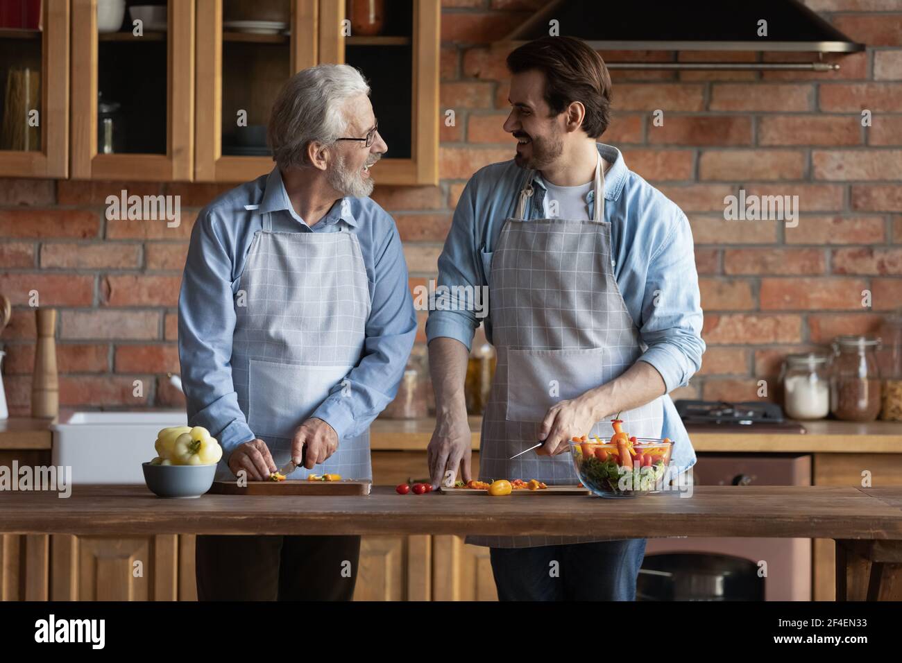 Smiling adult son and old father cook together Stock Photo - Alamy