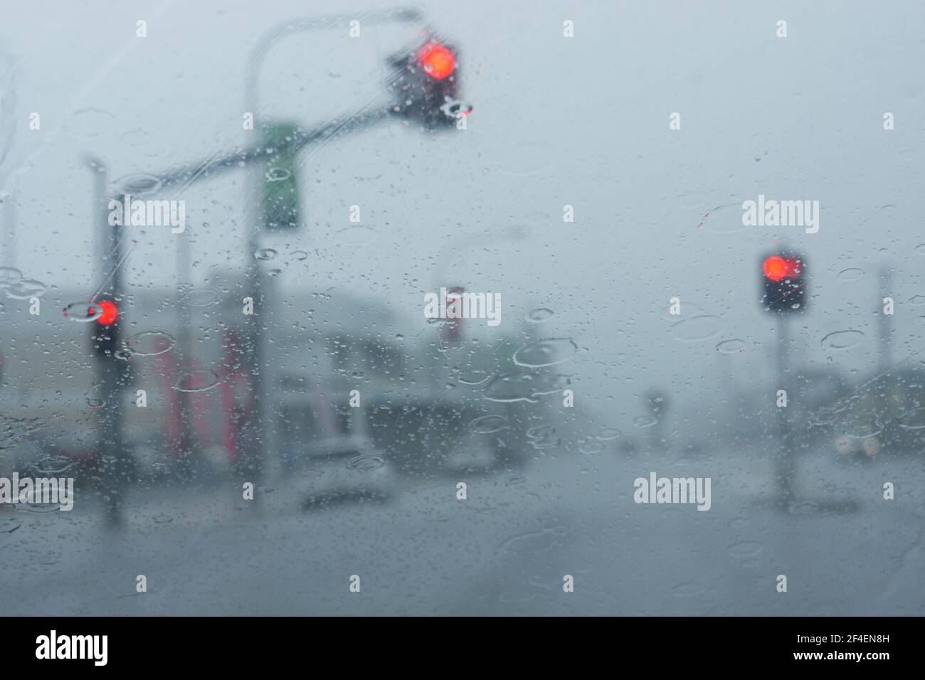 Red traffic lights on a city street seen through a vehicle windscreen ...