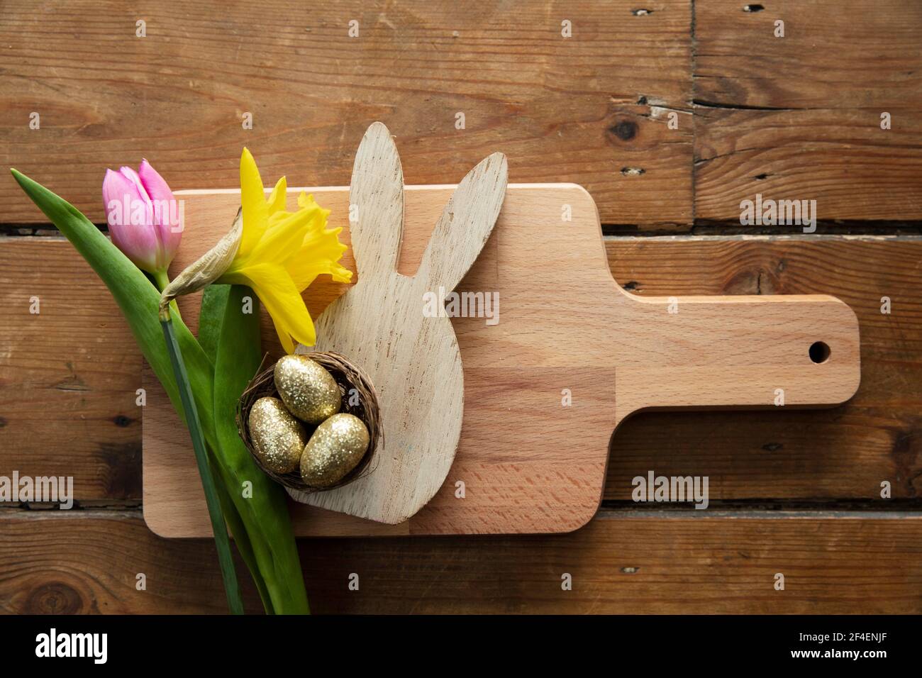 Easter table background. Spring flowers with a wooden bunny and easter ...
