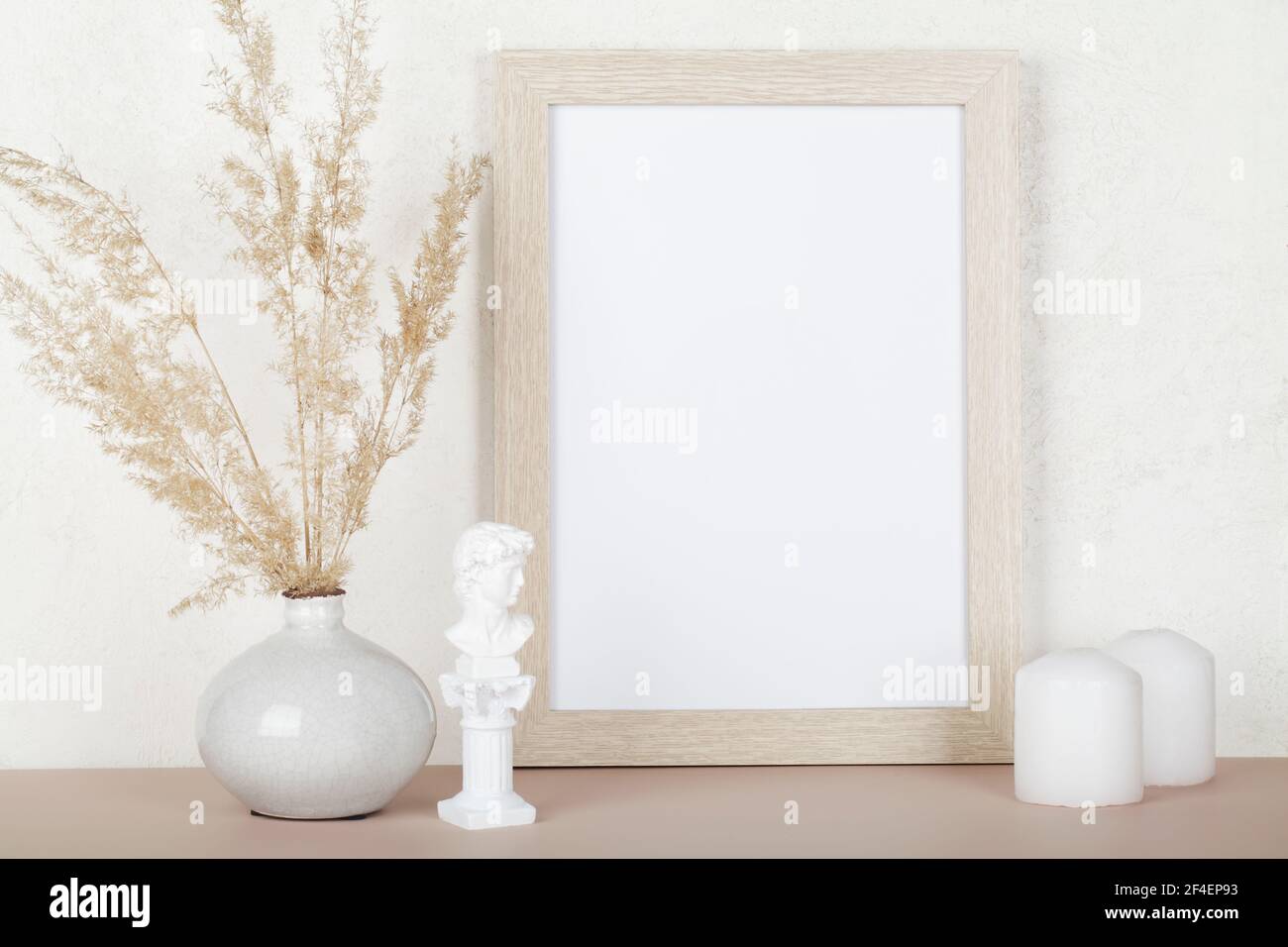 Portrait empty wooden frame mockup, dried pampas grass, small statue ...