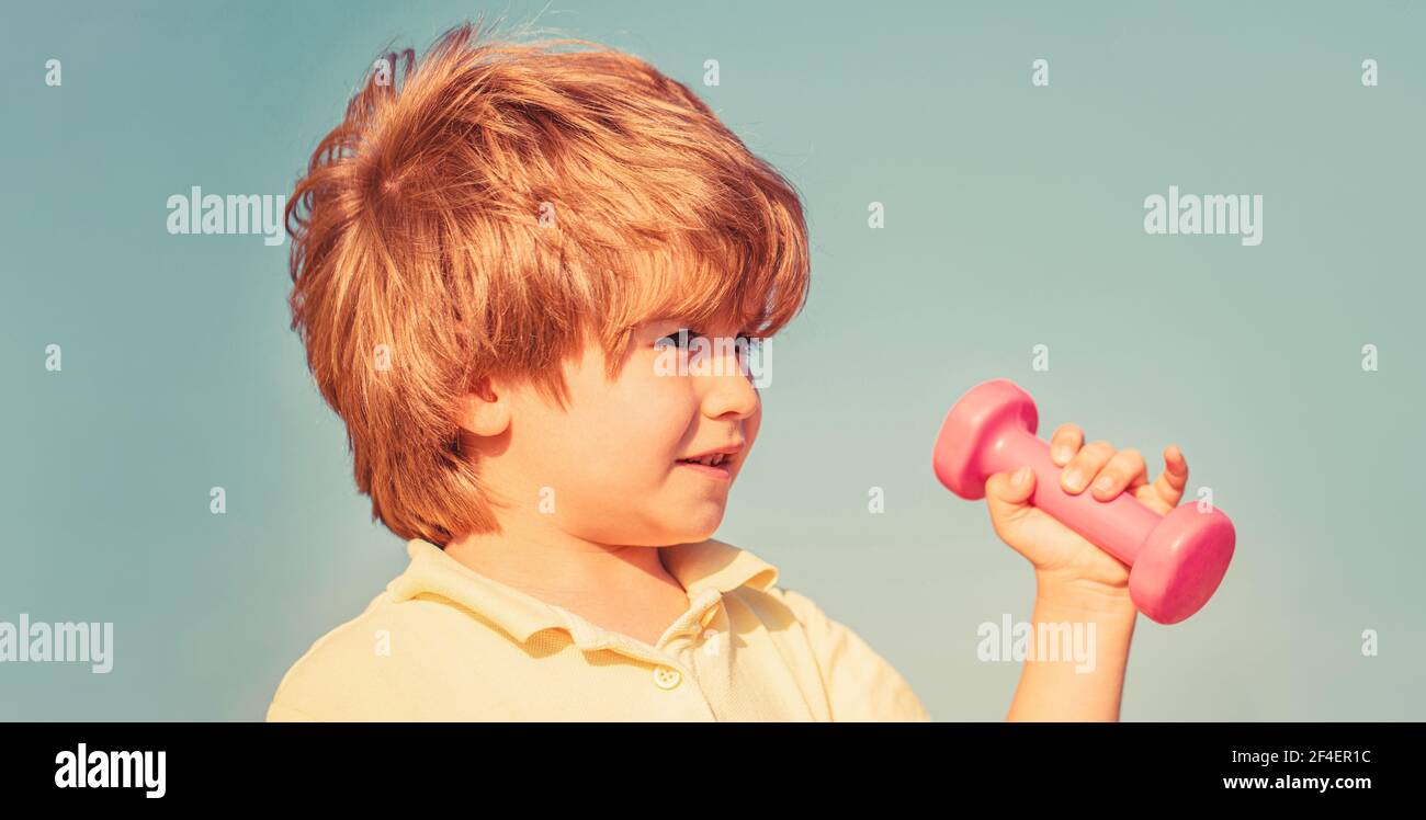 Cheerful boy do exercises with dumbbells. Kid exercising with dumbbells ...