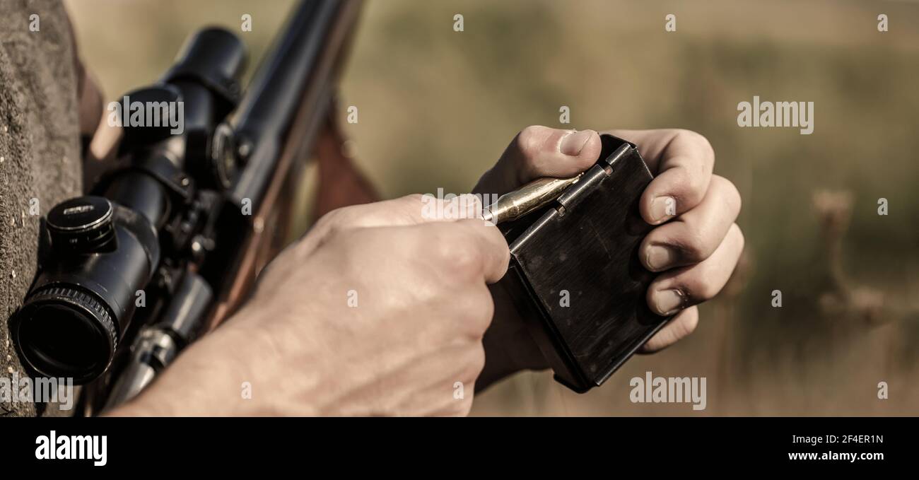 Man is charging a hunting rifle. Male hunter in ready to hunt. Closeup ...