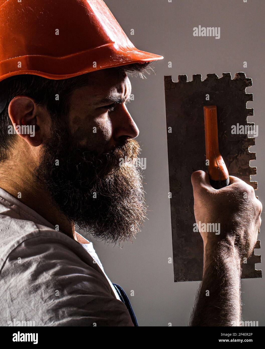 Bearded man worker, beard, building helmet, hard hat. Plastering tools ...
