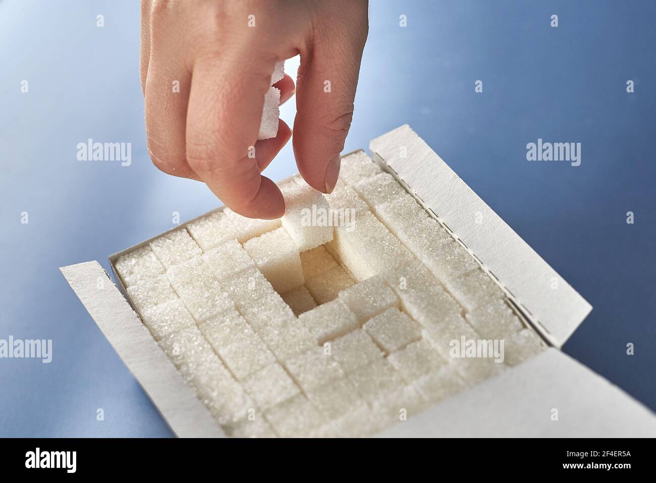 White sugar cubes in the hands of a woman, sugar in a paper box Stock ...
