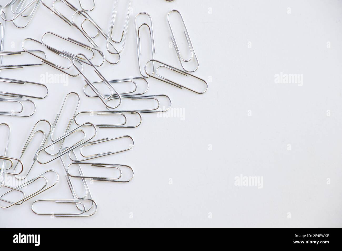 A pile of paper clips on white background Stock Photo - Alamy