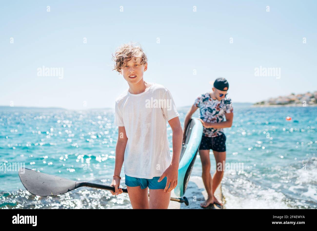 Beach board stand surfers hi-res stock photography and images - Alamy