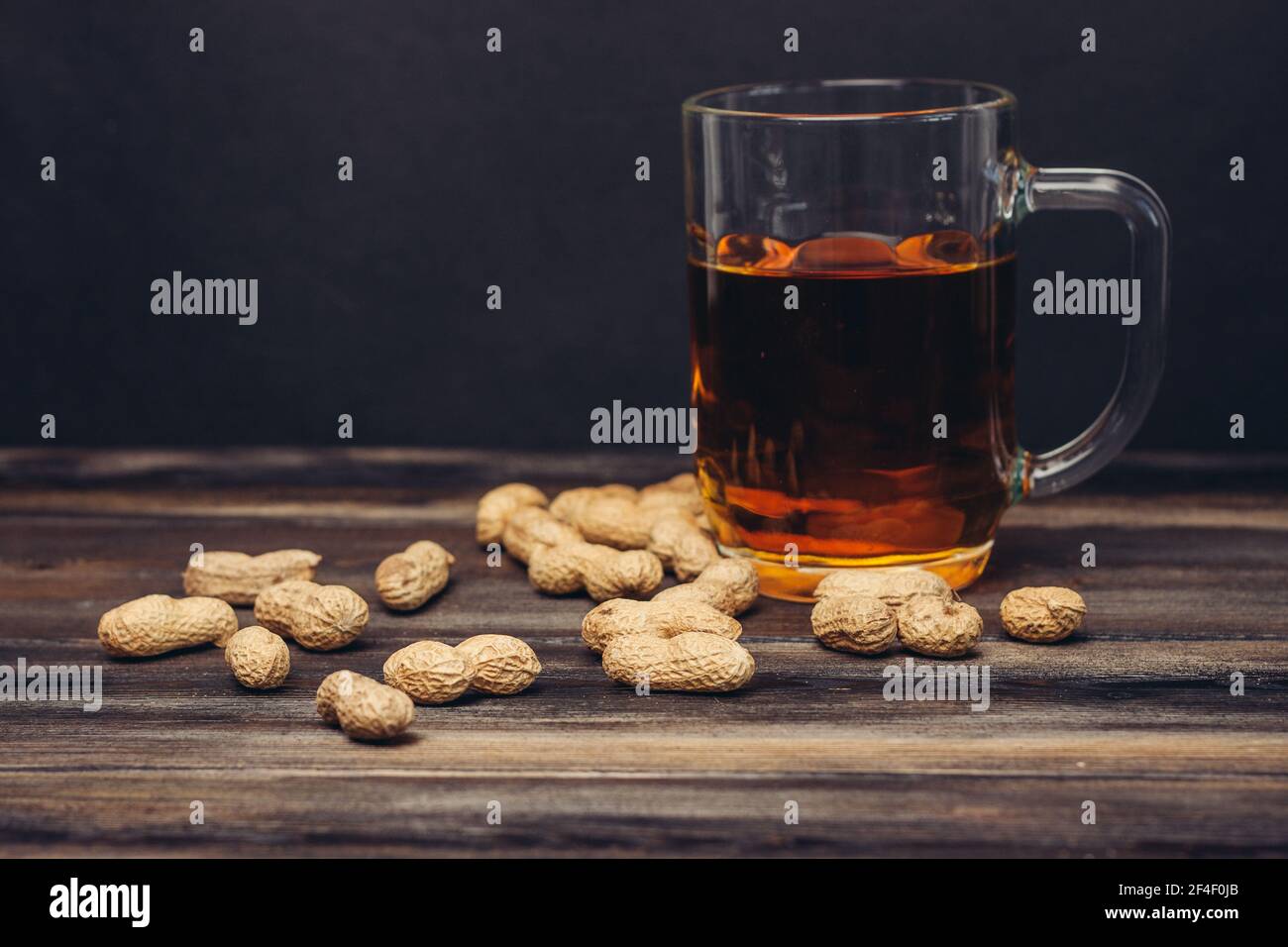 beer mug with peanuts in shells on wooden background pub alcoholic ...