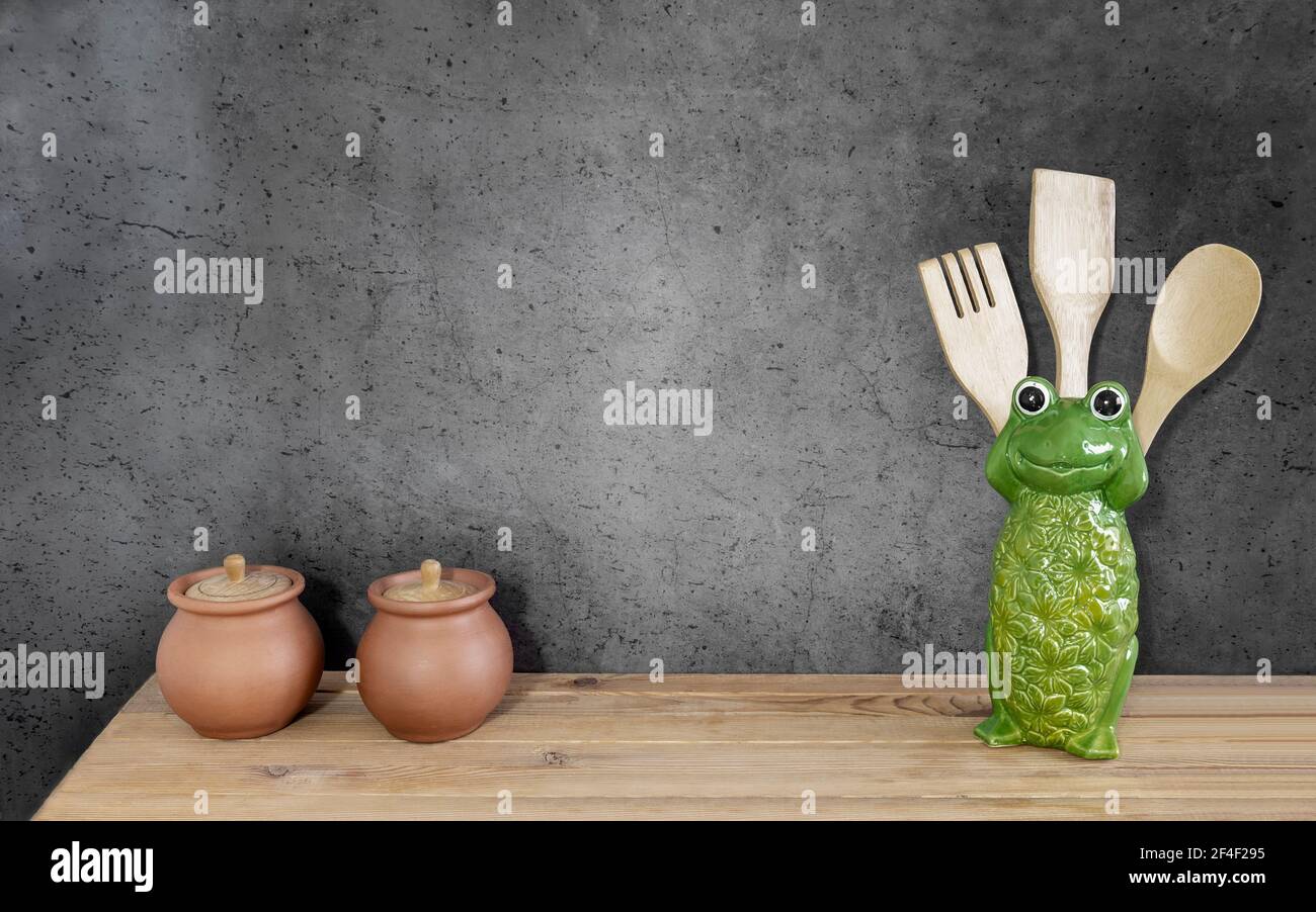 On the kitchen shelf are wooden cooking utensils and dishes. Front view ...