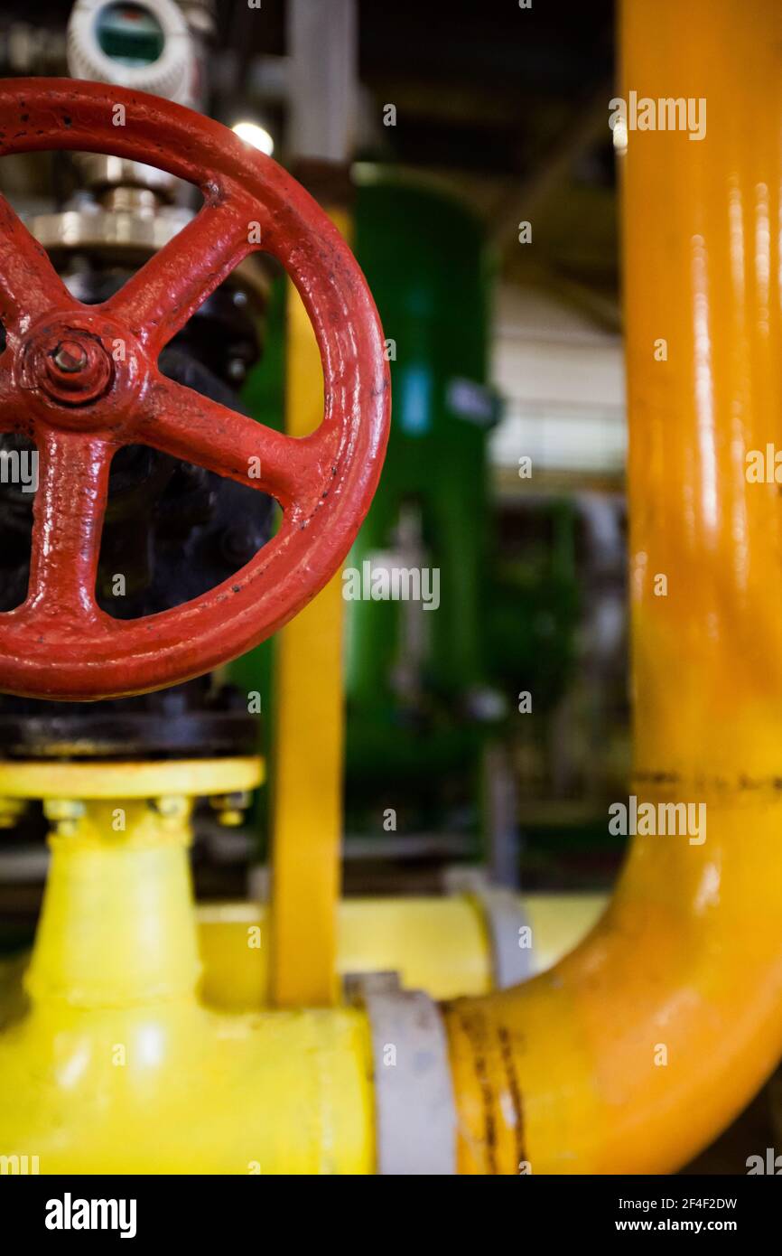 Close-up of yellow pipe and red valve armature. Abstract background on ...