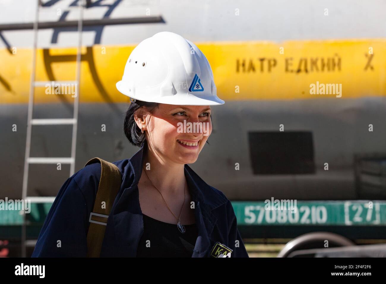 Caustic chemical plant. Young attractive engineer girl in white hardhat ...