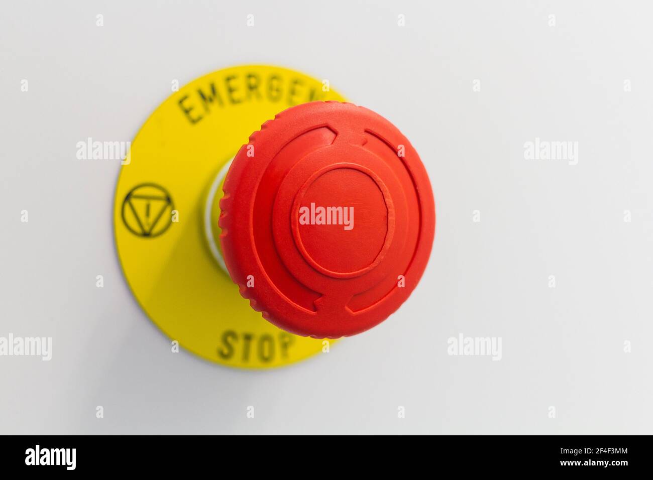 Press the emergency stop button on grey backround Stock Photo - Alamy