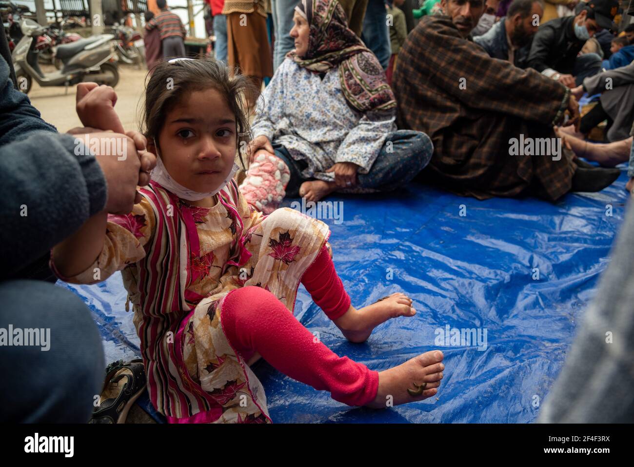 Srinagar, India. 21st Mar, 2021. A Kashmiri girl looks on as she ...