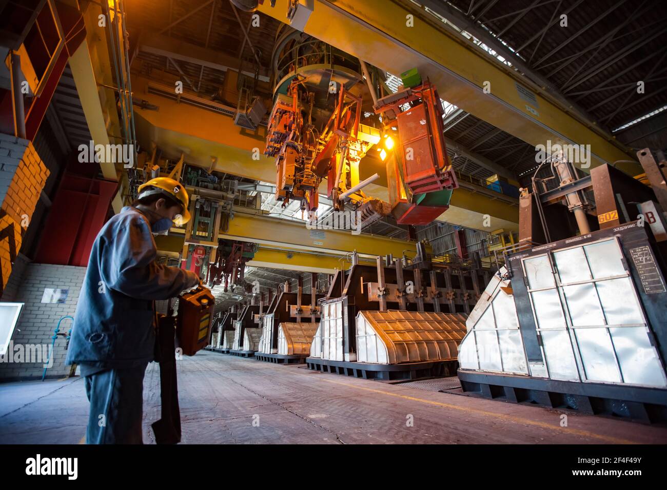 Aluminum electrolysis plant. Operator worker with remote control in ...
