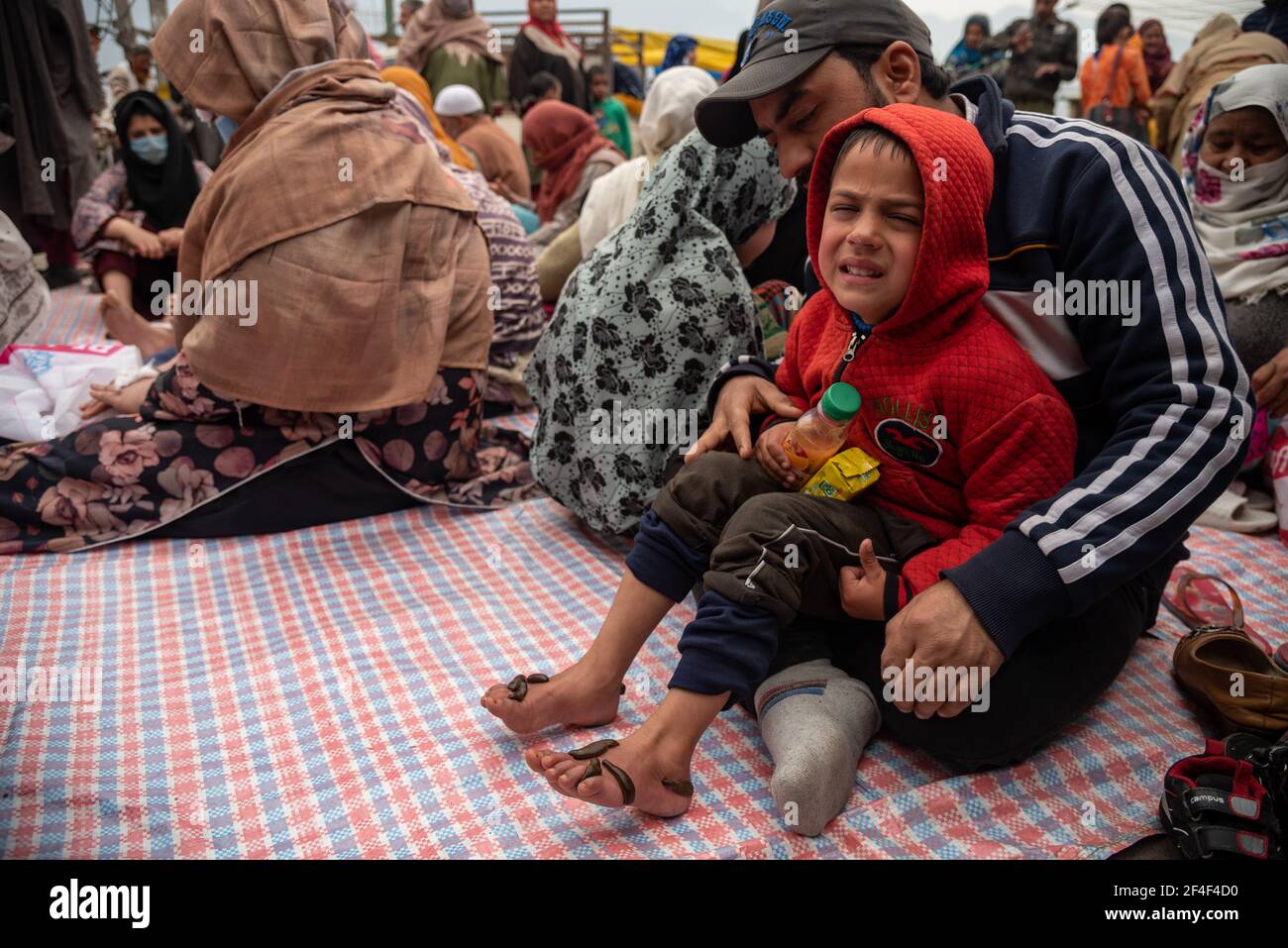 Srinagar, India. 21st Mar, 2021. A Kashmiri boy cries as he receives ...