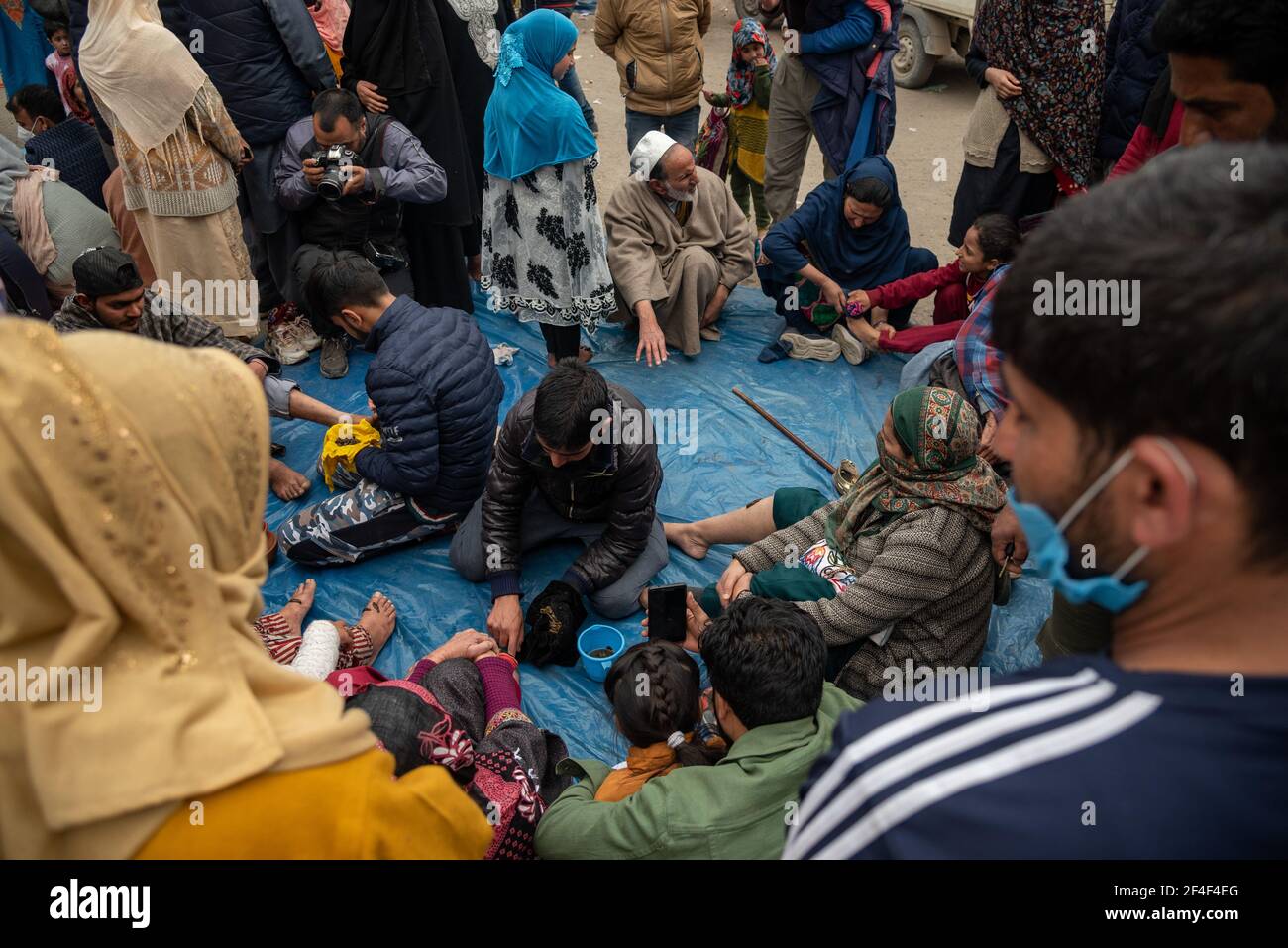 Srinagar, India. 21st Mar, 2021. People receive leech treatment on bank ...