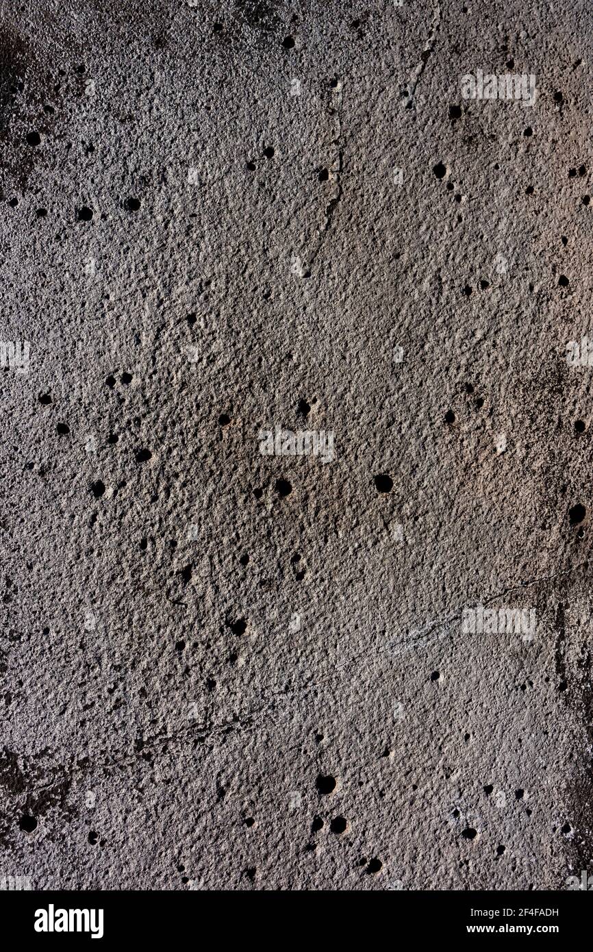 Surface of gray porous plaster with traces of treatment in sunlight ...