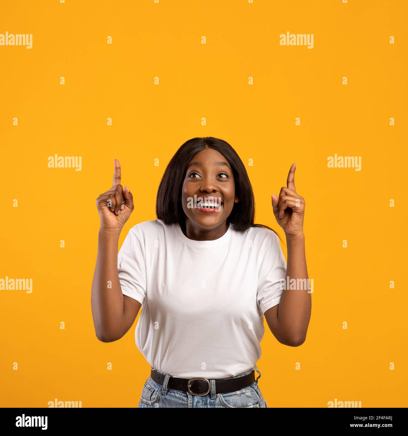 Emotional black lady pointing up at copy space Stock Photo - Alamy