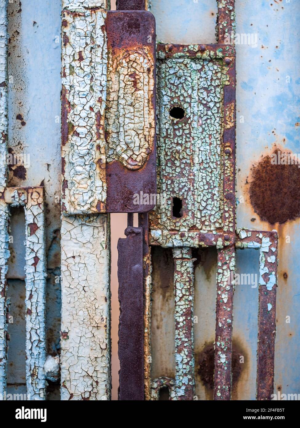 Rusted and with old paint covered metallic entrance gate lock Stock ...