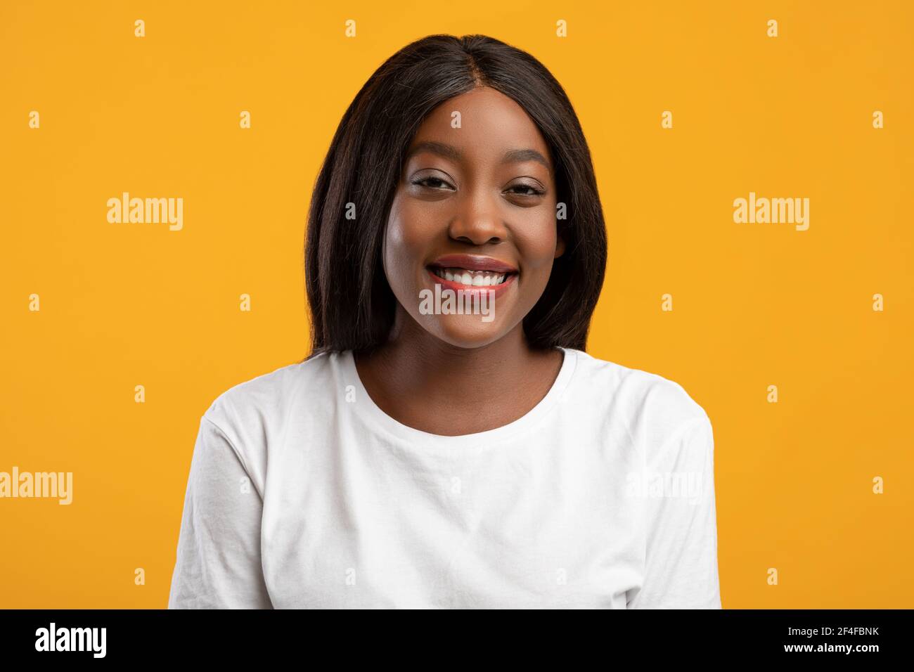 Closeup of cute black lady posing on yellow studio background Stock ...