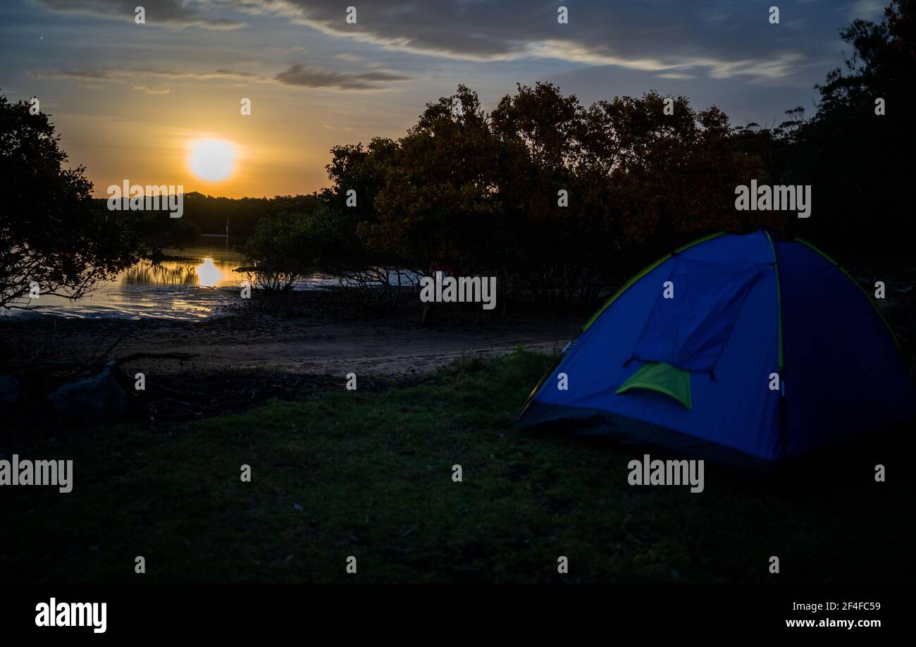 Moon setting and its reflection while camping Stock Photo - Alamy