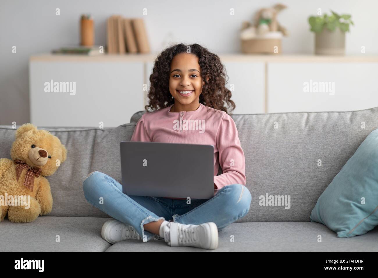 Happy african american teen girl using laptop computer, browsing ...