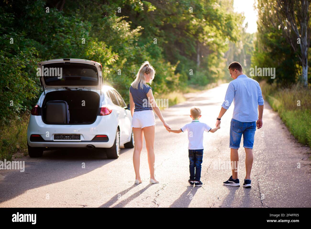 Young family travels by car. Dad, mom and son take a break from driving ...
