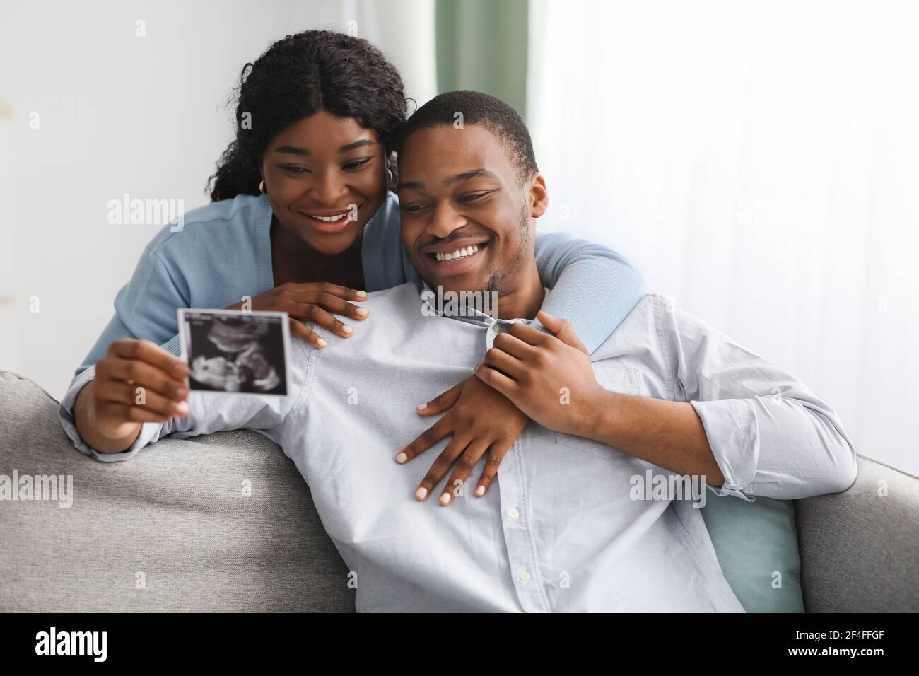 Happy black couple looking at baby sonogram Stock Photo - Alamy