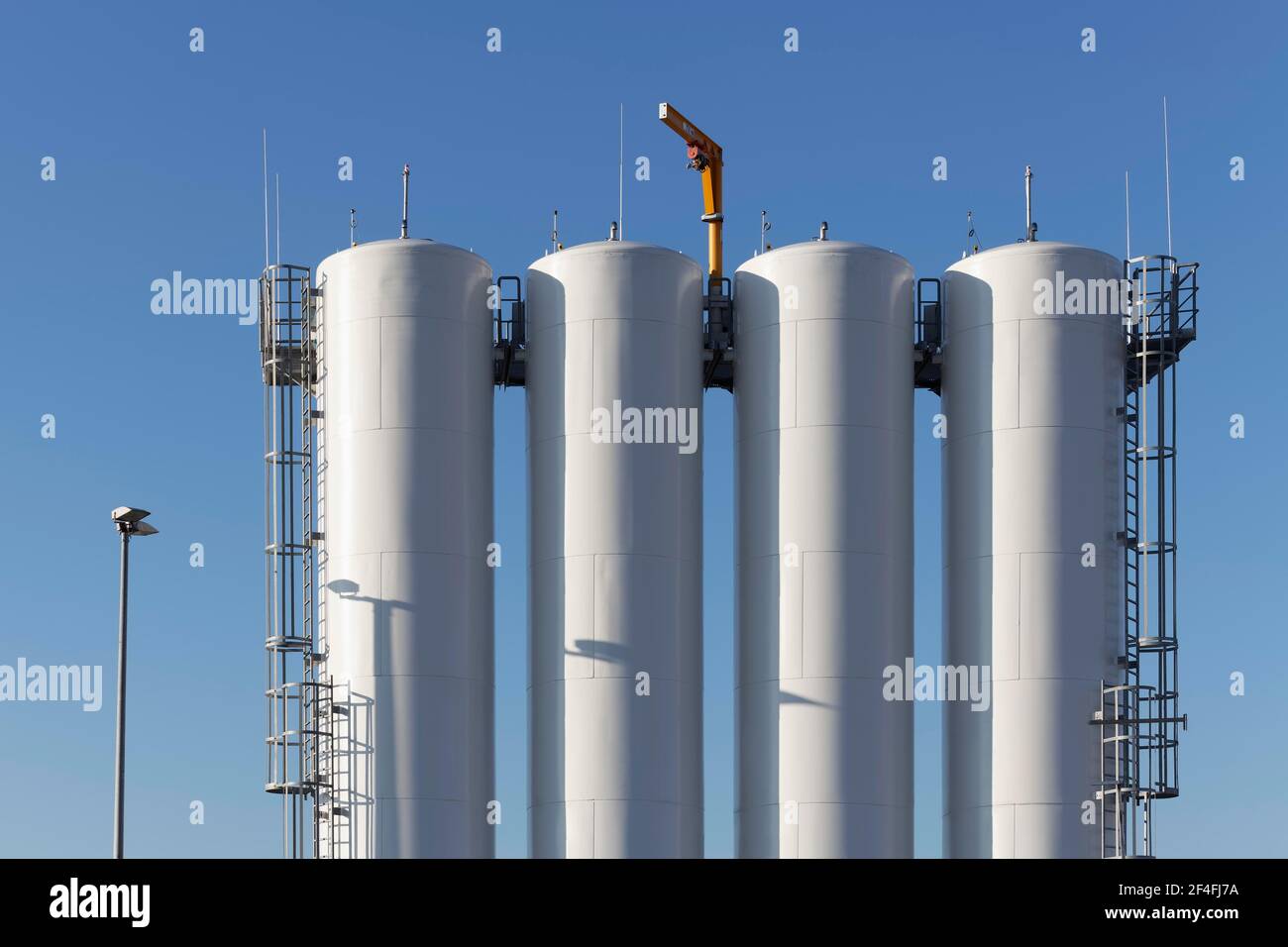 Storage tanks for de-icing fluid, painted white, against blue sky ...