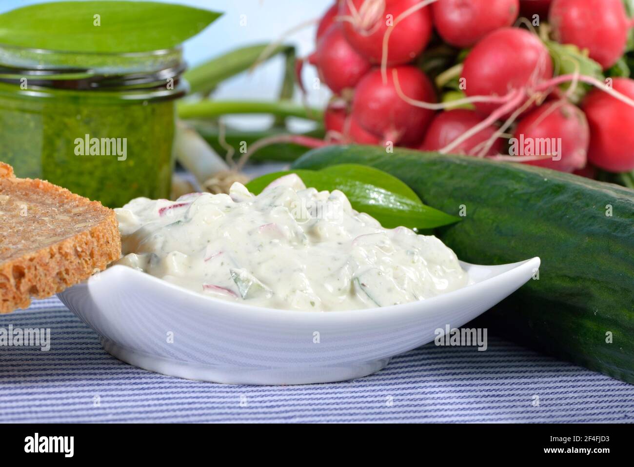Spring dip with young onions (Allium cepa), wild garlic and radishes ...