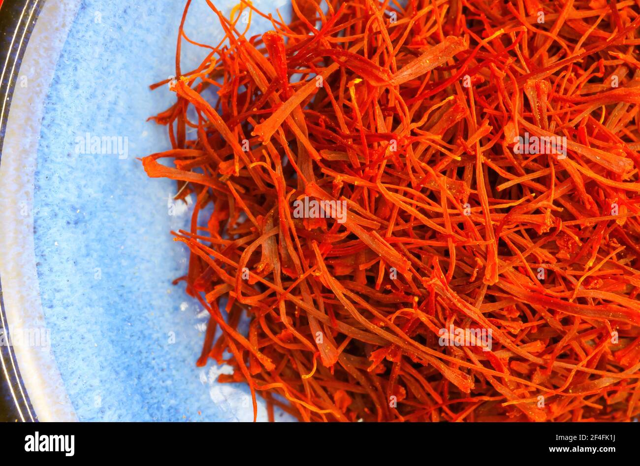 Makro closeup of isolated red dried saffron threads on blue plate Stock ...
