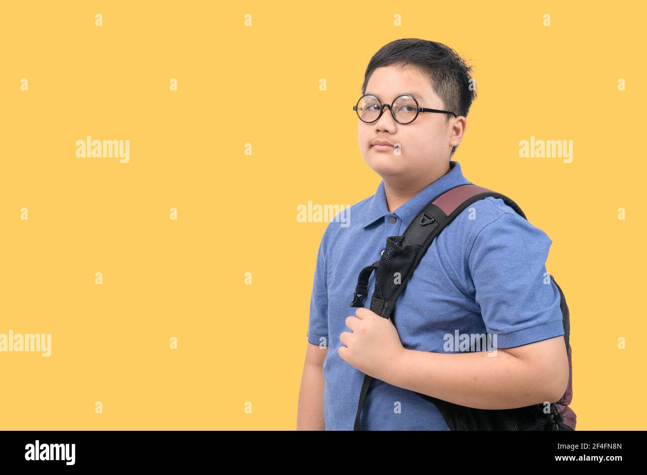Handsome boy student carrying a school bag isolated on yellow ...