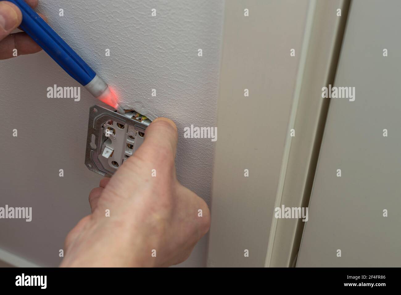 Сlose up view of man checks voltage in the electrical outlet. Sweden ...