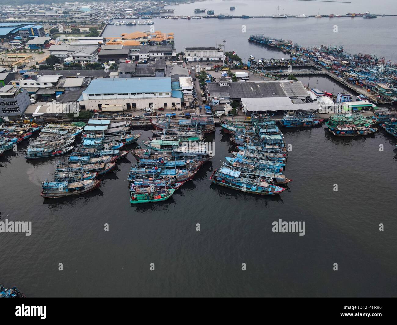 Aerial drone view of Muara Angke Beach with wooden boats leaning beside ...