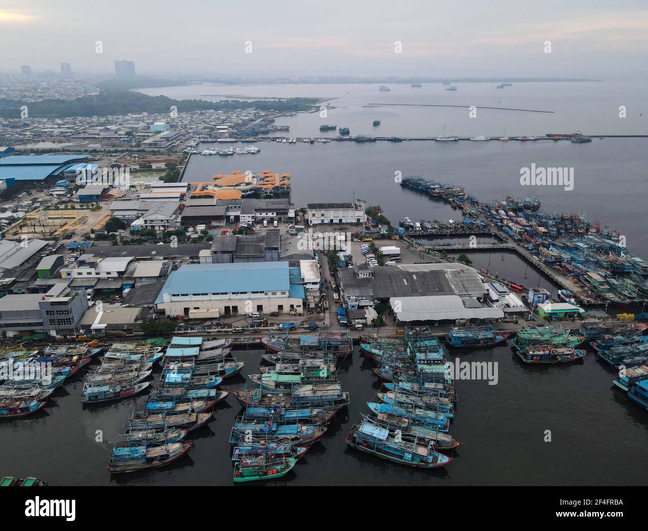 Aerial drone view of Muara Angke Beach with wooden boats leaning beside ...