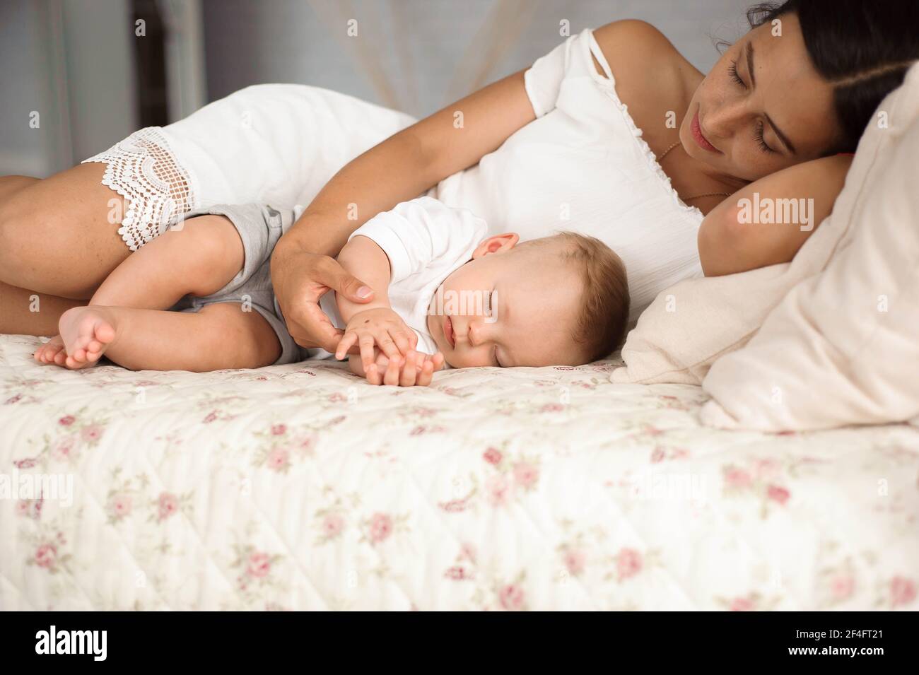 Little boy lies near his mom resting on the bed Stock Photo - Alamy