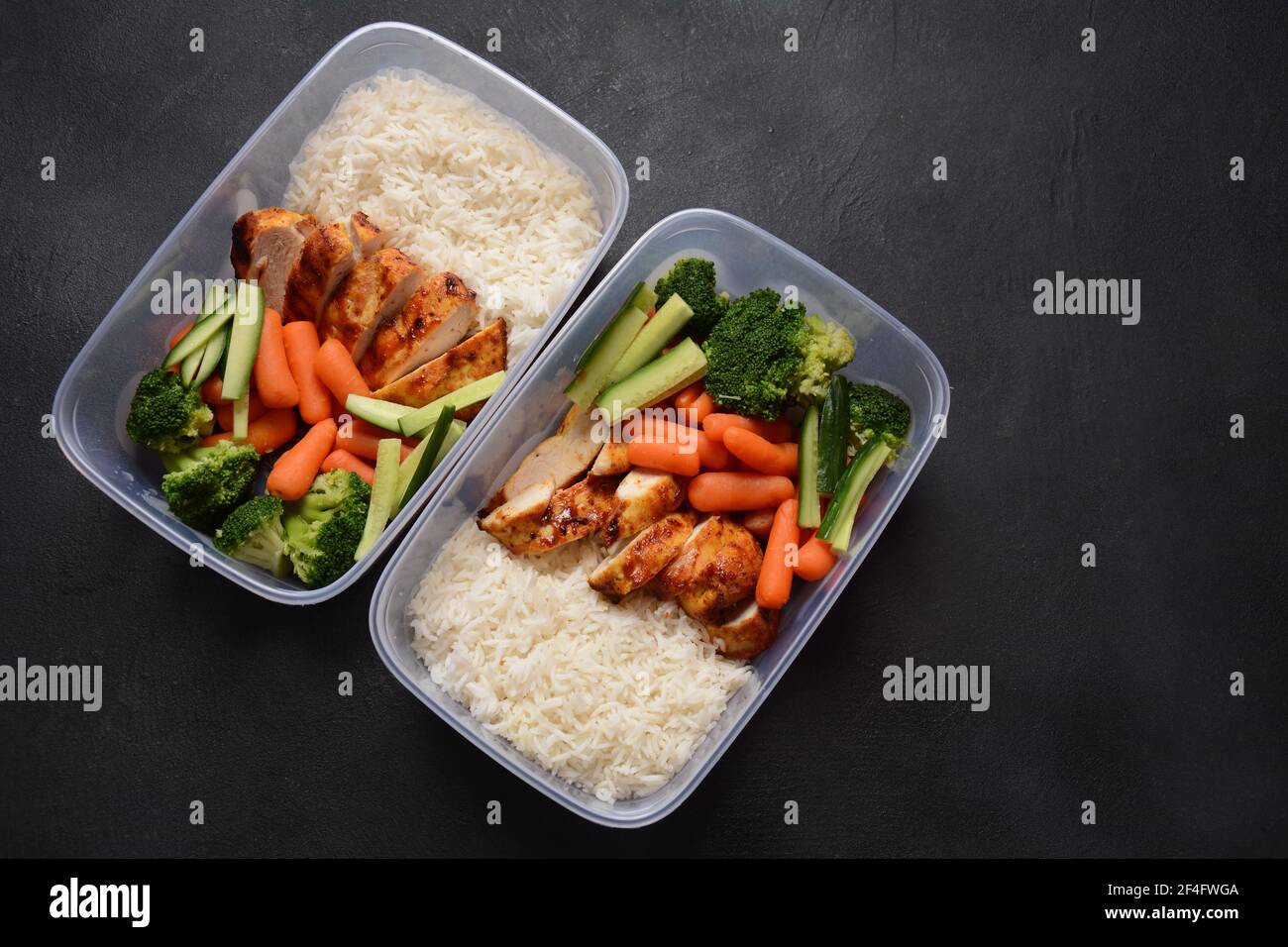 Healthy balanced lunch boxes. Grilled chicken, carrots, cucumbers ...