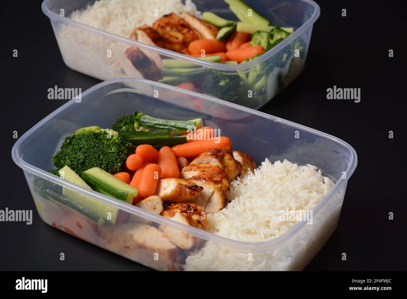 Healthy balanced lunch boxes. Grilled chicken, carrots, cucumbers ...