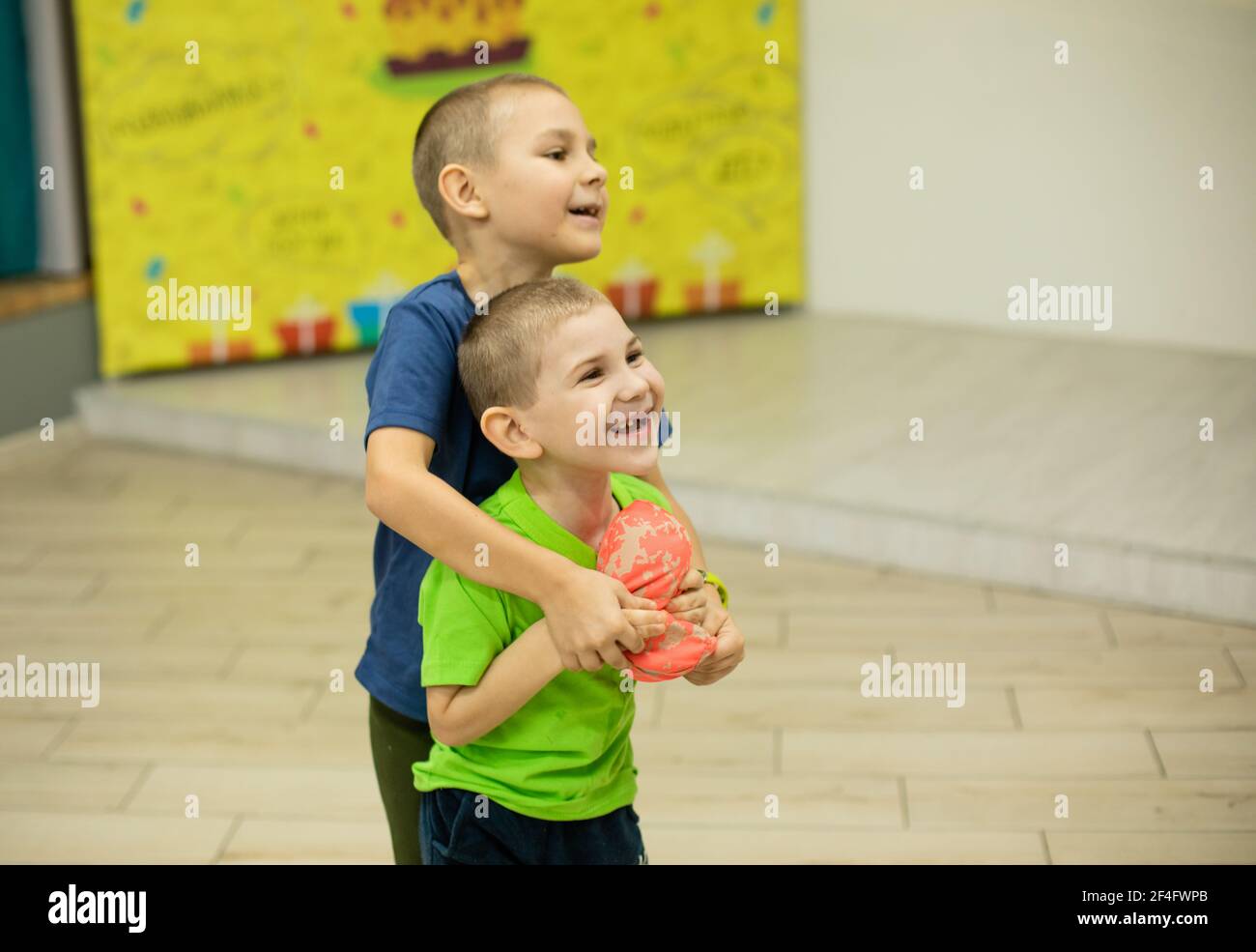 Two cheerful little brothers are playing with soft toy Stock Photo - Alamy