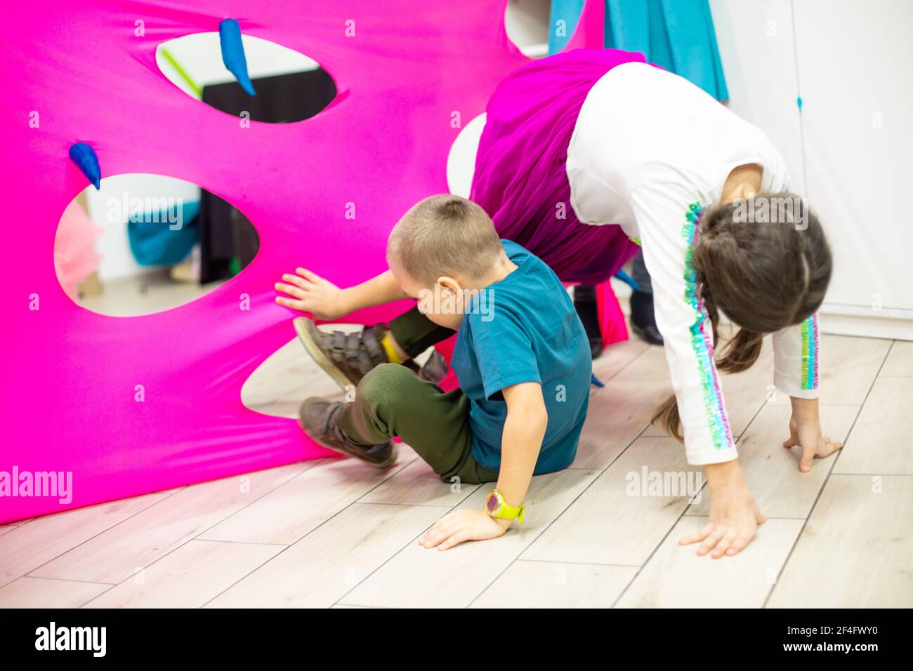 The children are crawling through holes in the fabric Stock Photo - Alamy