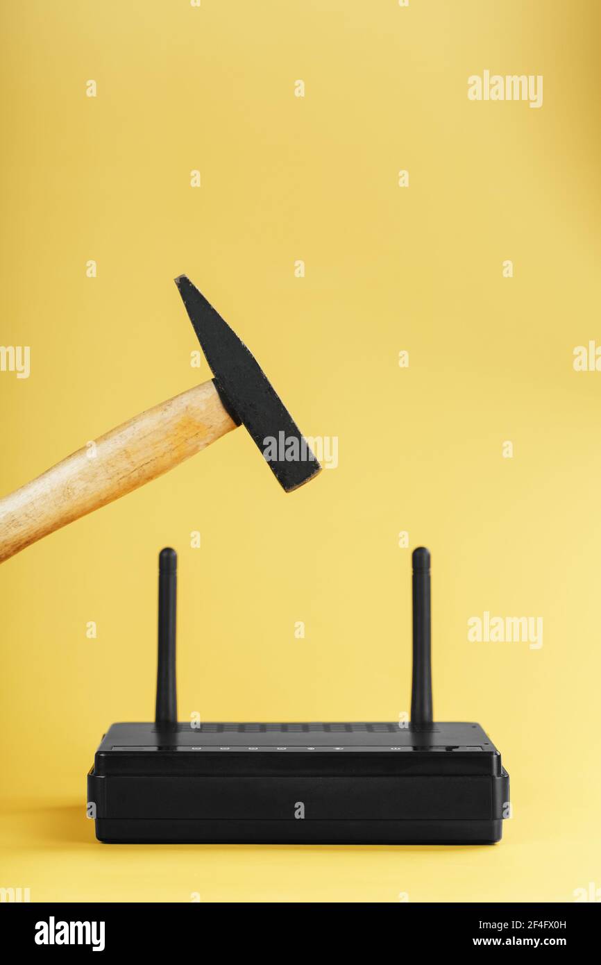 Hammer over the Wi-Fi router for destruction on a yellow background ...