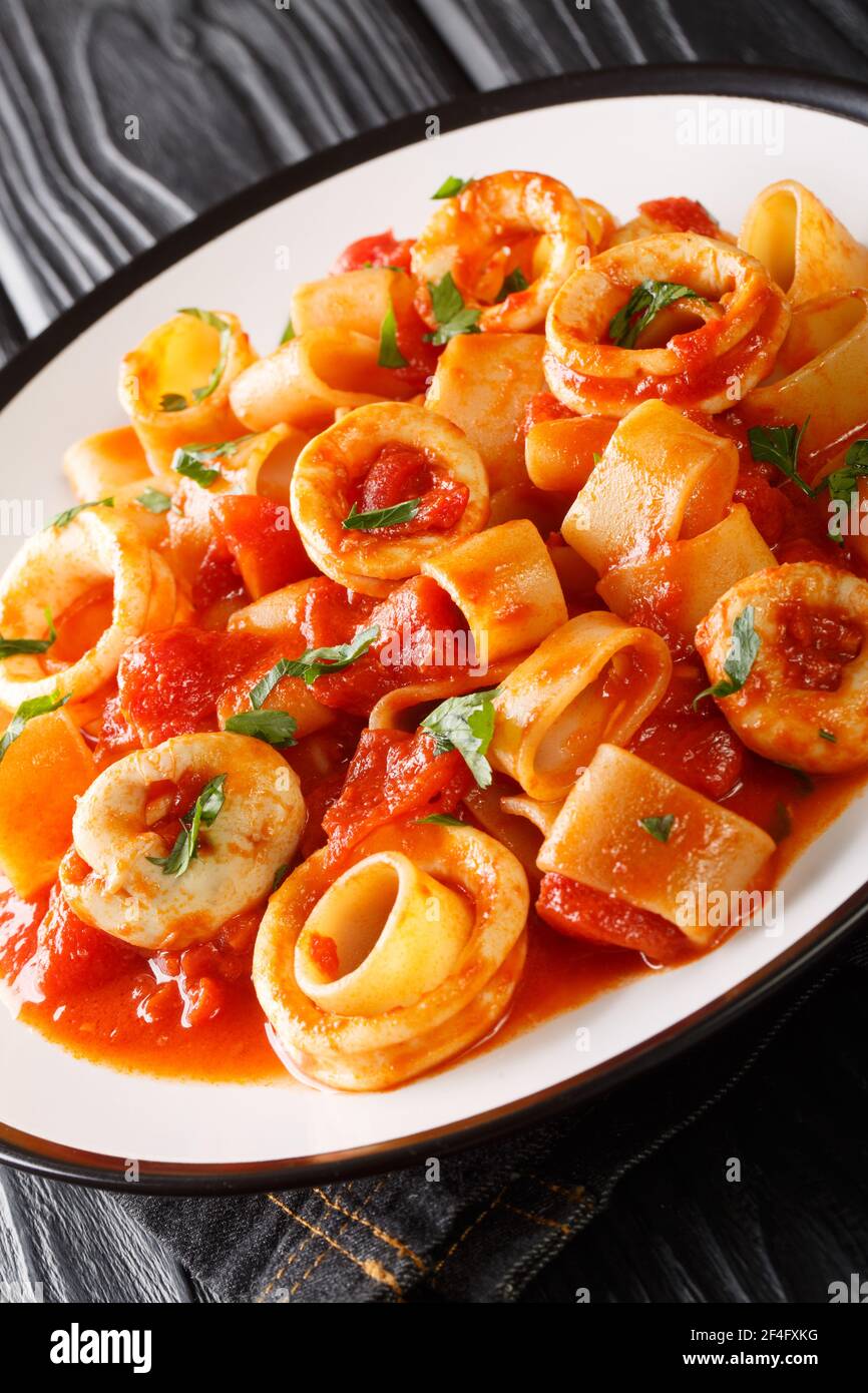 Calamarata pasta with squid in a spicy tomato sauce close-up in a plate ...