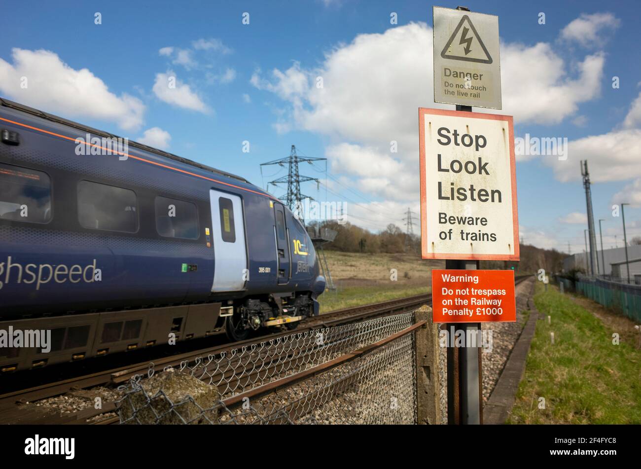 Landscape image of signage by train tracks in Sturry, Kent, displaying safety rules as train ...