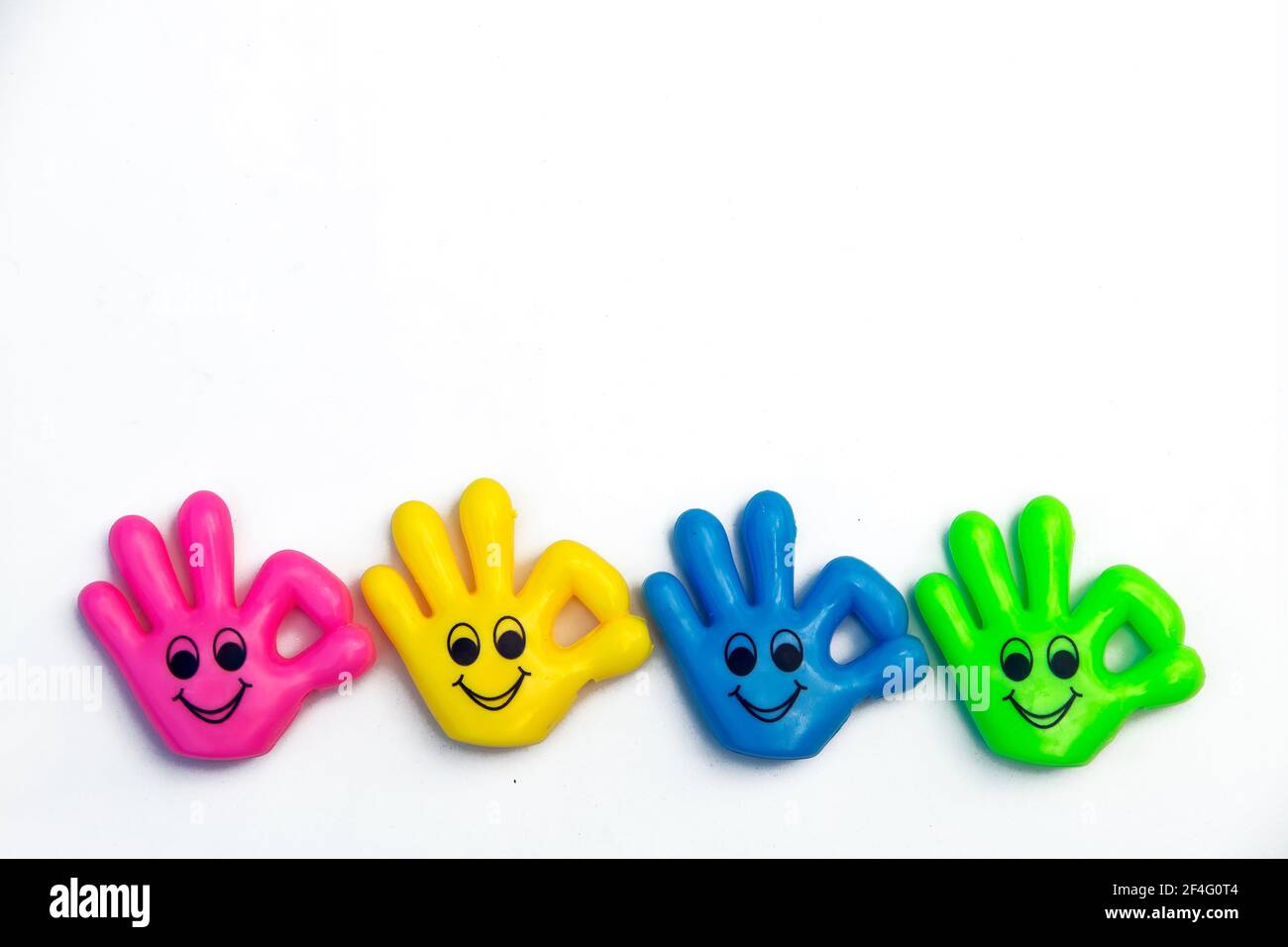 Four colour small plastic hands with smile on face making the OK sign ...