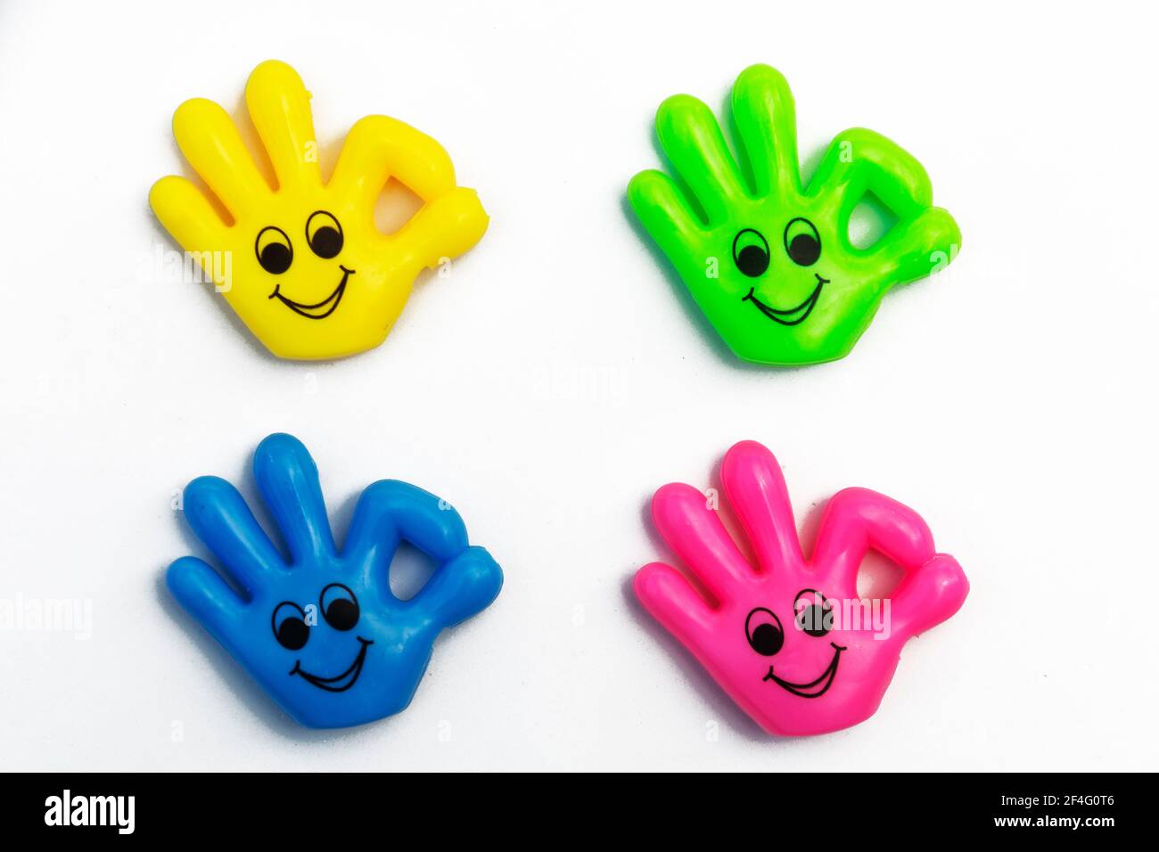 Four colour small plastic hands with smile on face making the OK sign ...