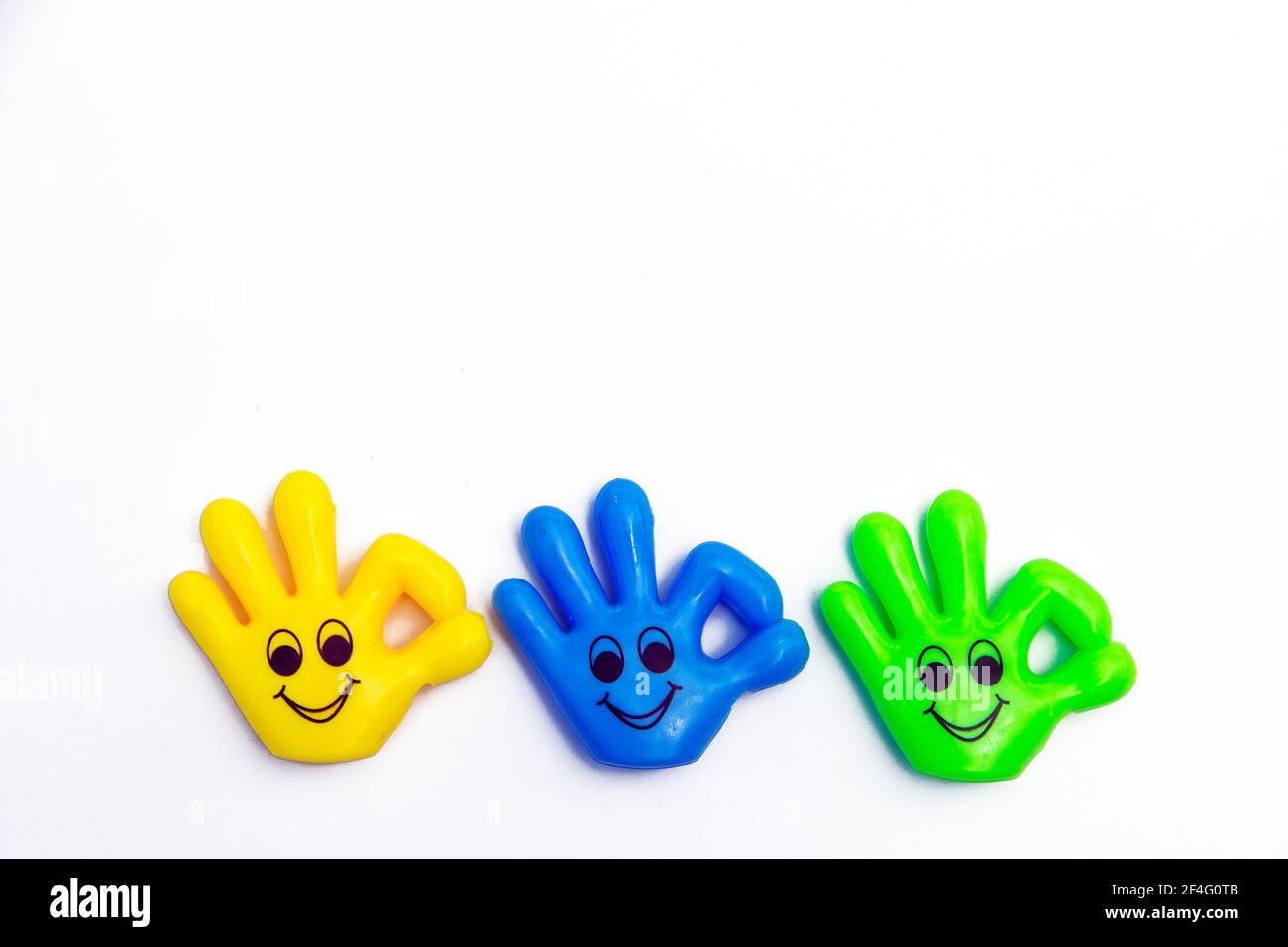 Three colour small plastic hands with smile on face making the OK sign ...